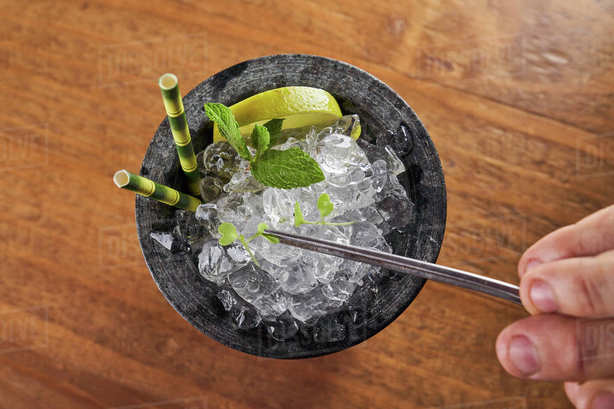 Fresh cold ready beverage with ice and straw in modern ceramic cup on ...