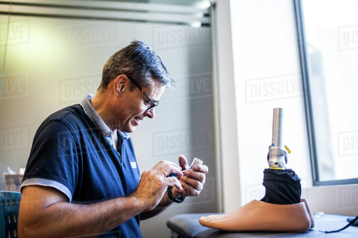 Prosthetic engineer reviewing the prosthesis of a patient and improving ...