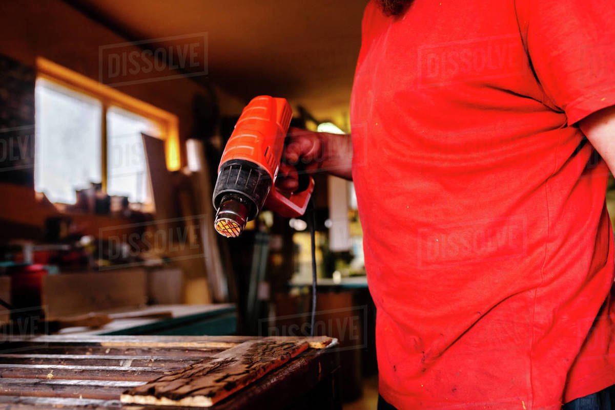Unrecognizable male carpenter standing at workbench and drying piece of ...