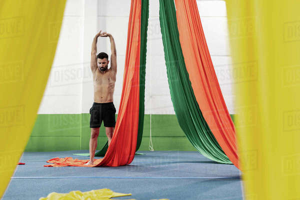 Full body muscular man raising arms over head and stretching near ...