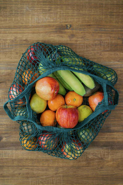 Top view of assorted fresh fruit in cotton eco friendly sacks placed on ...