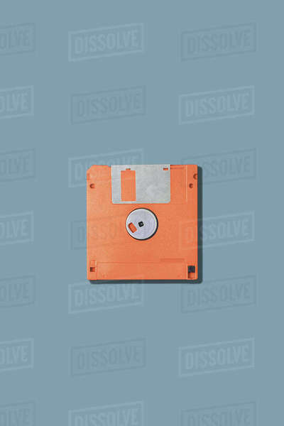 Top view of old fashioned orange magnetic floppy disk for computer ...