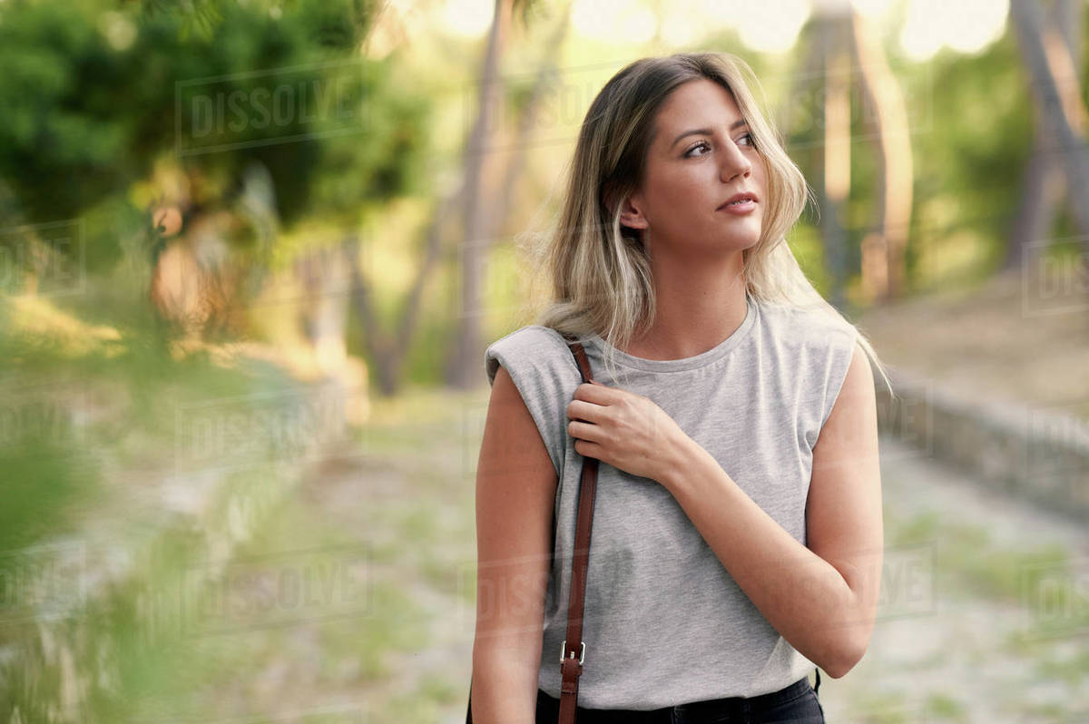 Calm confident young female in casual outfit enjoying sunny summer day ...