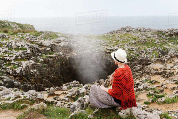 Back view of unrecognizable female traveler in stylish knitwear and hat ...