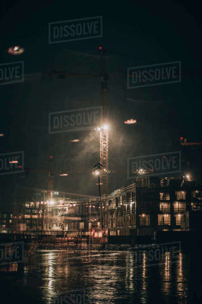 Tower crane at construction site in old city district near river and ...