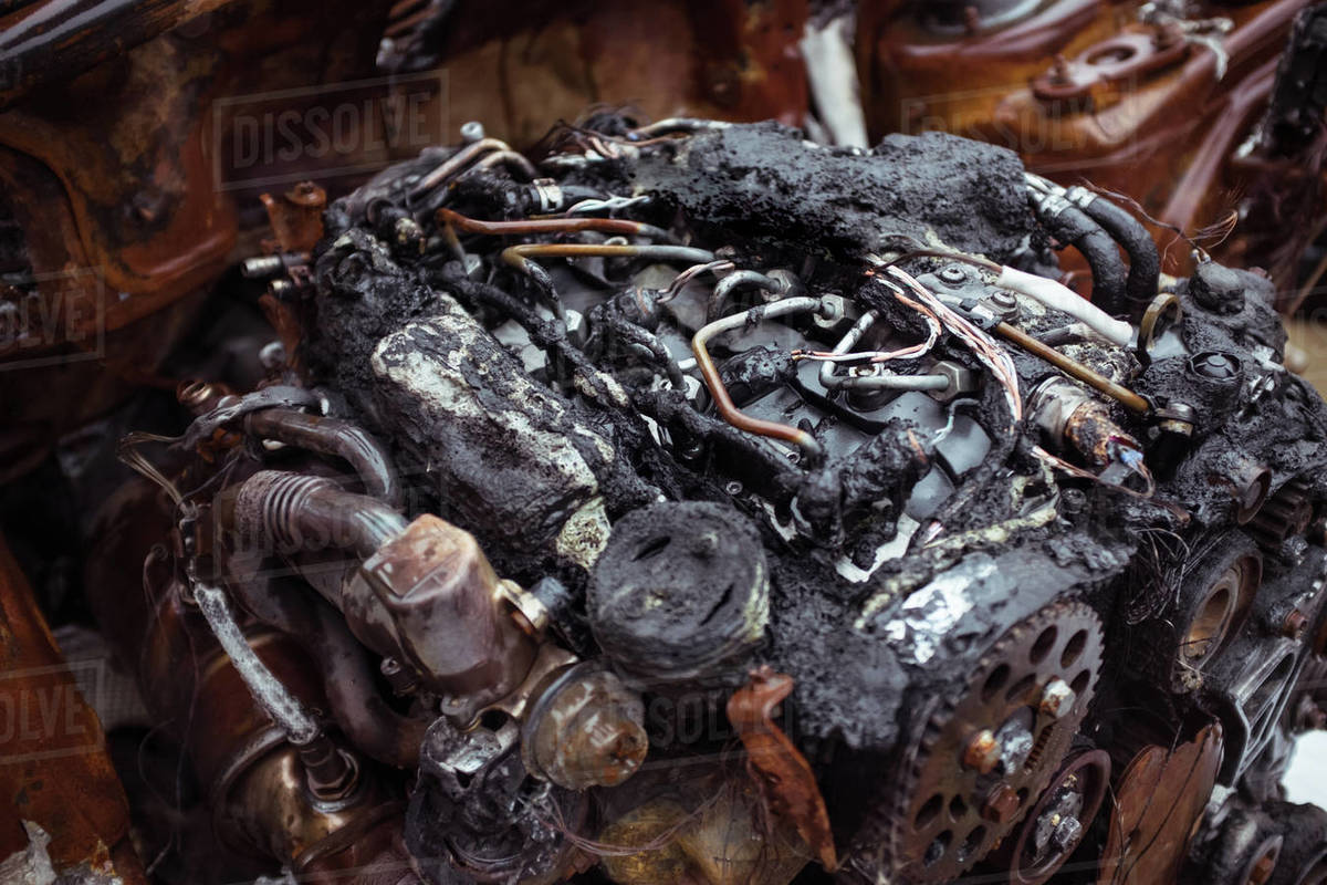 From above of ruined auto hood with burned radiator tank and motor near ...