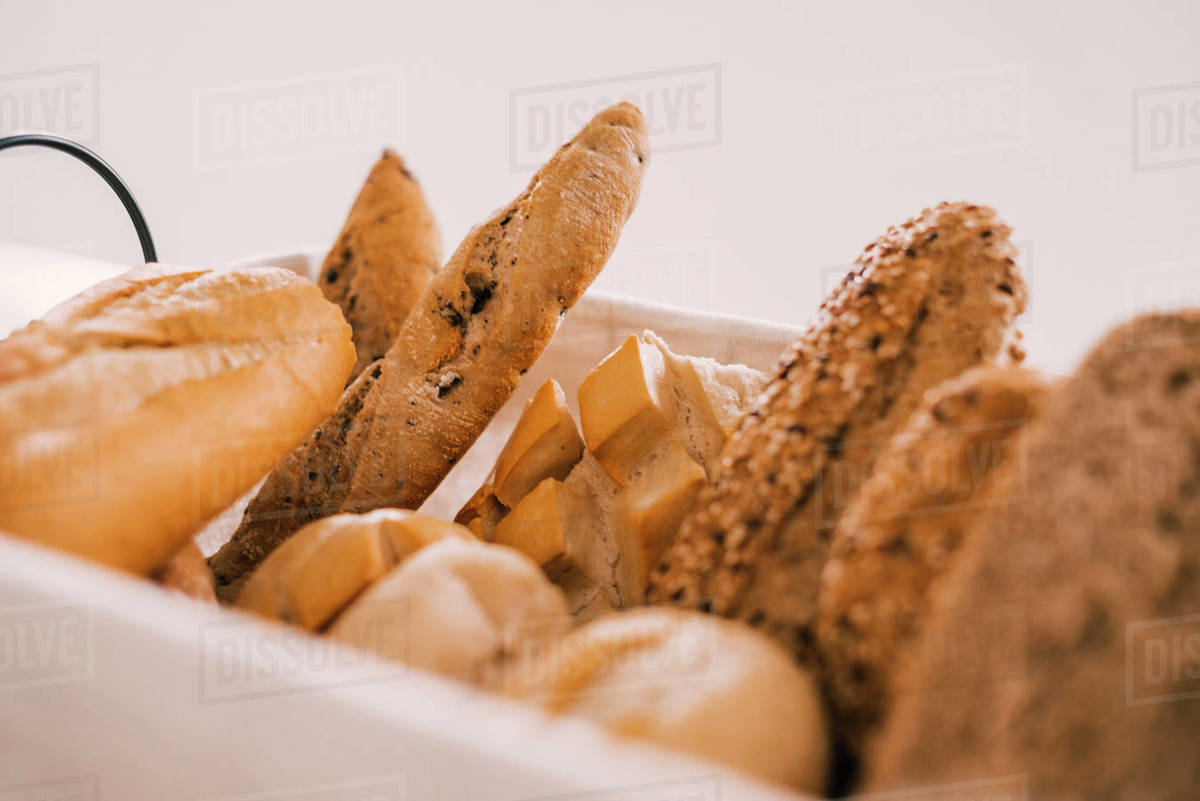 Fresh assorted cut bread and buns served in tray on white table during ...