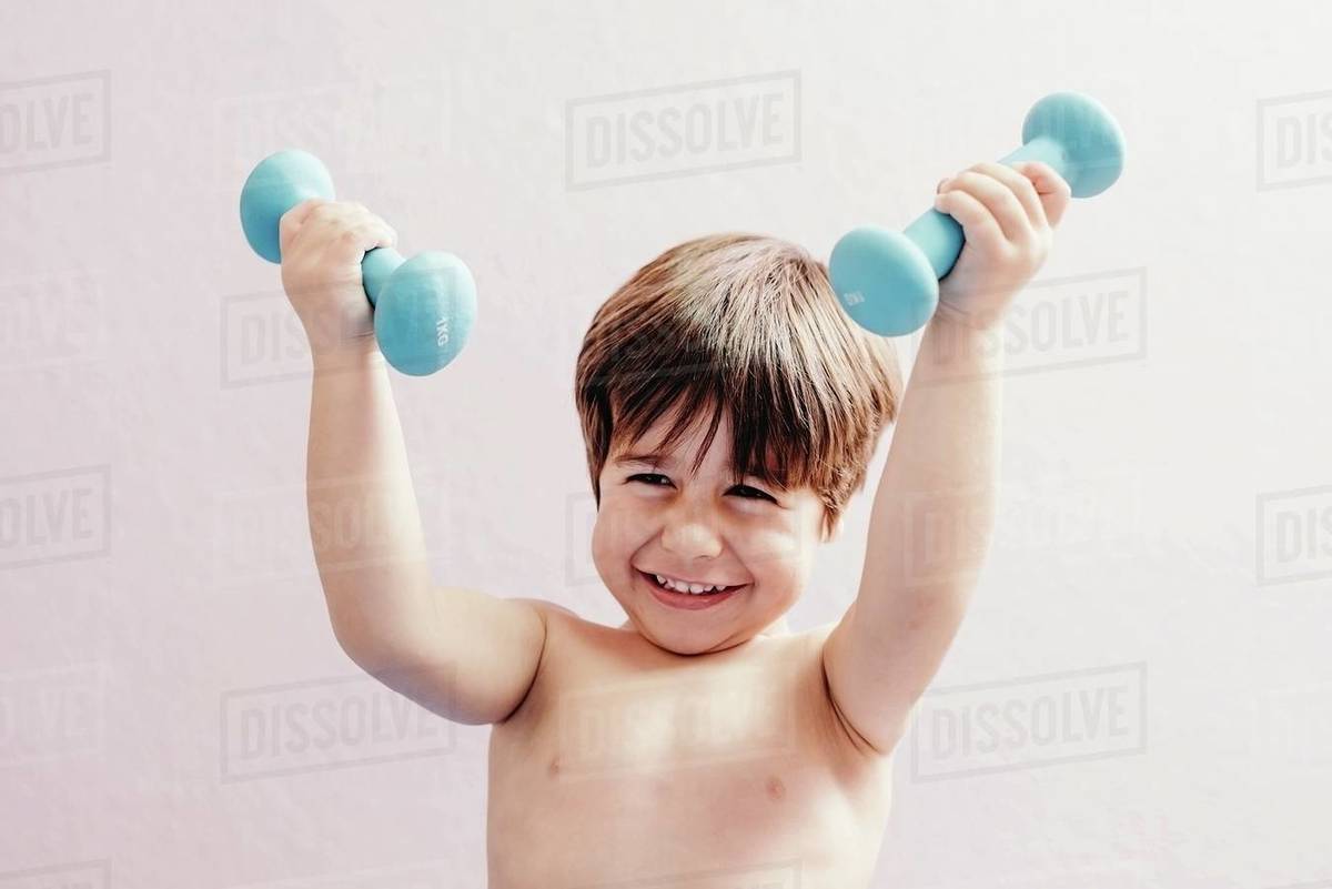 Cheerful little boy with dumbbells - Royalty-free Stock Photo | Dissolve