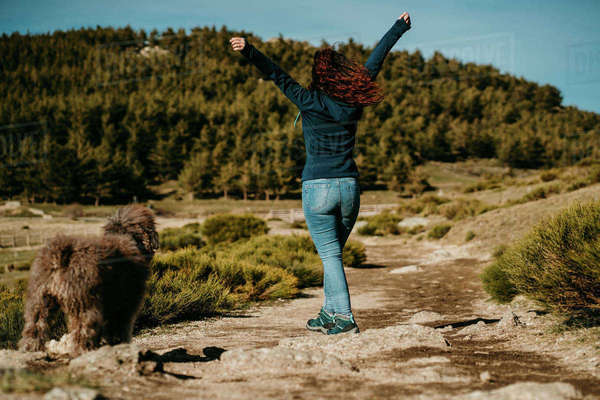 Back view of unrecognizable happy female smiling and following fluffy ...