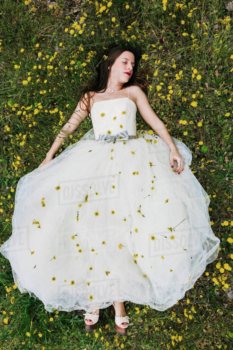 Relaxed bride lying in meadow with flowers - Royalty-free Stock Photo ...