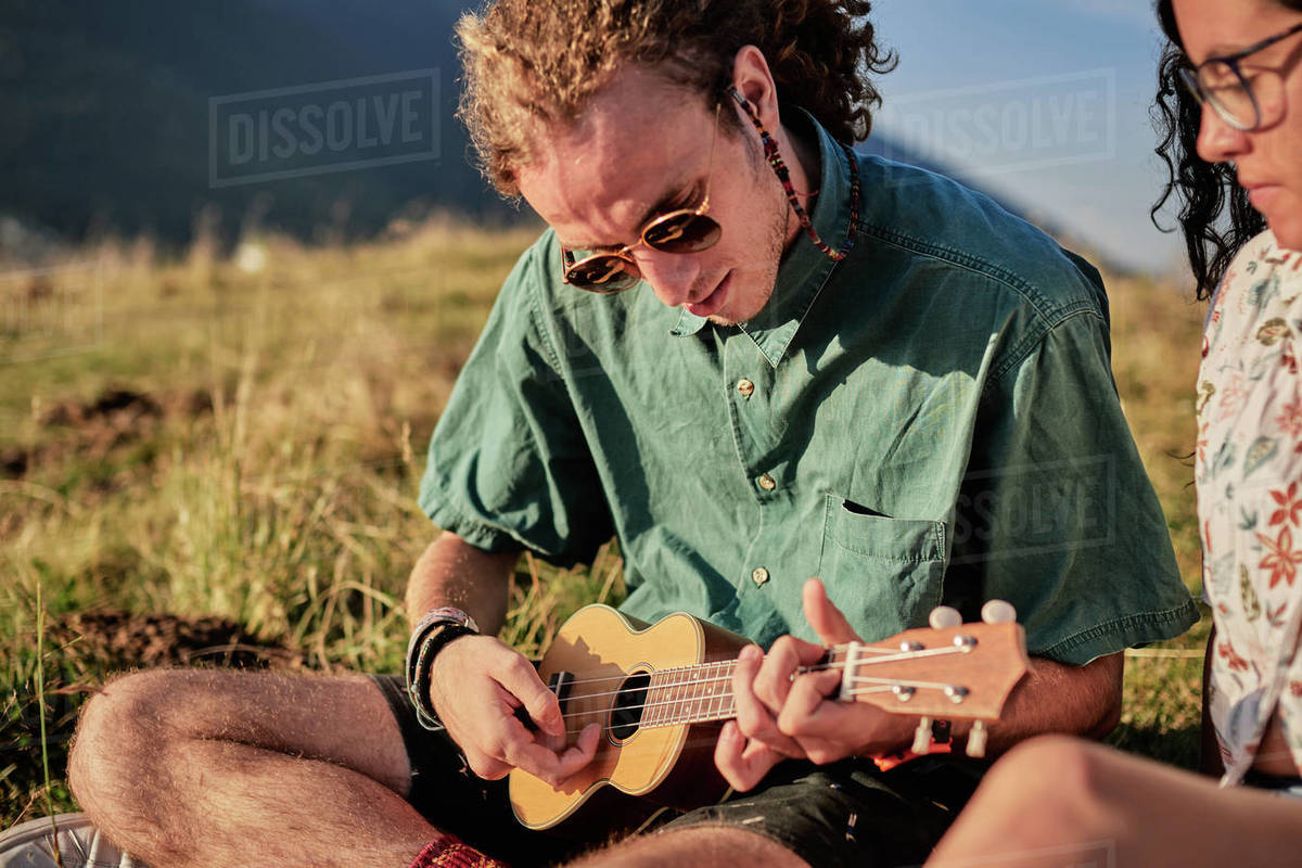 Cheerful friendly people playing ukulele while entertaining during ...