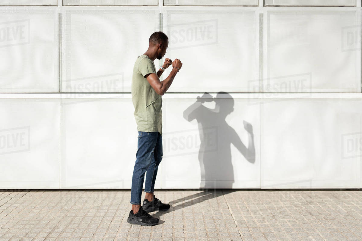 Side view of African American male standing in city in fighting ...