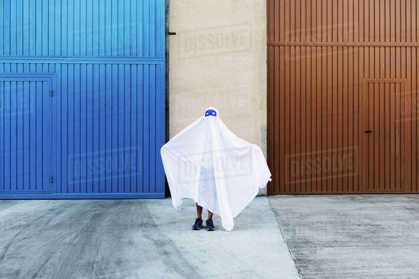 Faceless child in white ghost costume frightening with outstretched ...