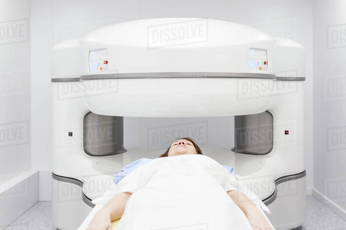 middle-aged woman on an open MRI machine waiting for the test to begin ...