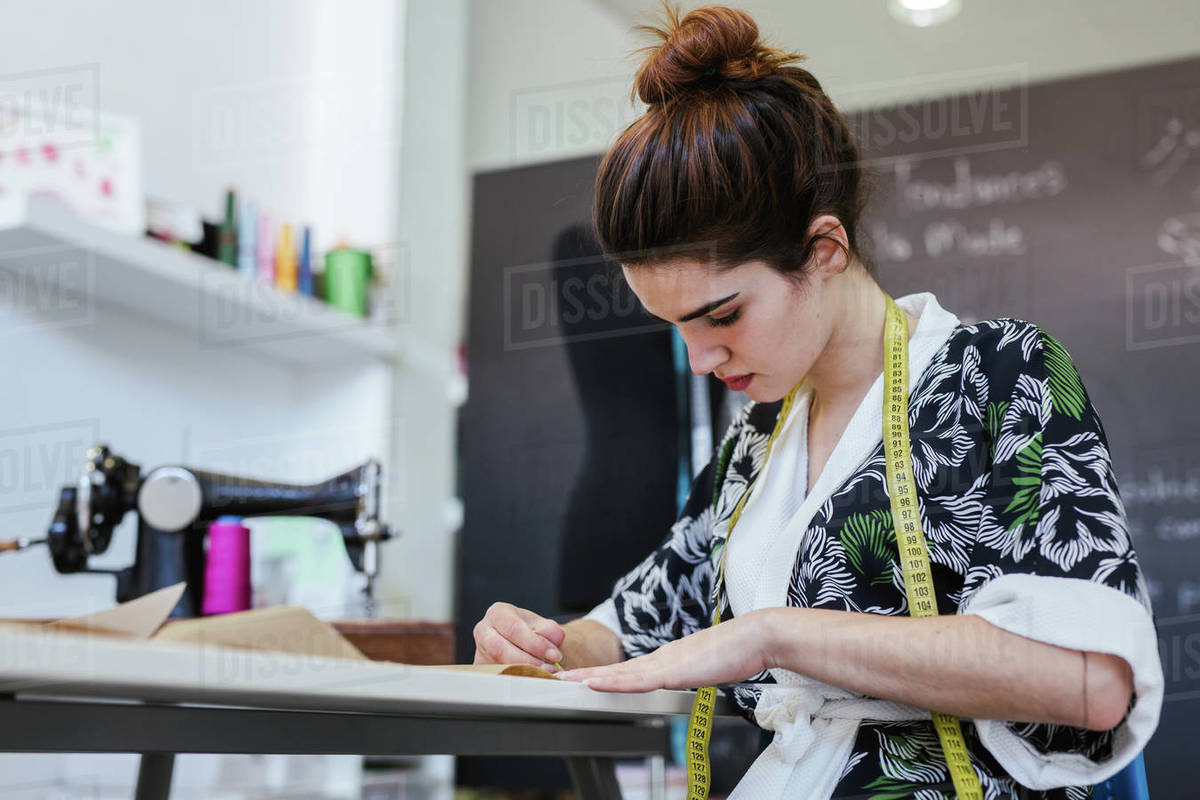 Teenage girl student practicing sewing on modern machine in cozy ...
