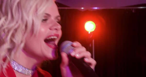 Portrait of artistic sensual woman singer emotionally sings a song on ...