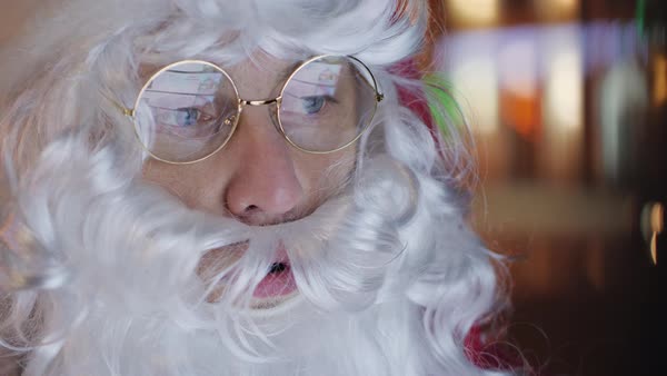 Close up face of Santa Claus in traditional festive costume with uses a ...