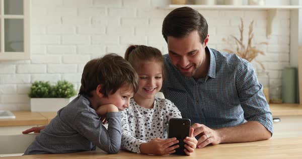 Dad with kids having fun using smart phone application - 4K Royalty ...