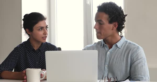 Two multiracial colleagues talking sit at desk in office. - Stock Video ...