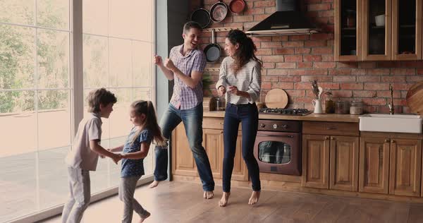 Happy family with little kids dancing barefoot in kitchen - Stock Video ...