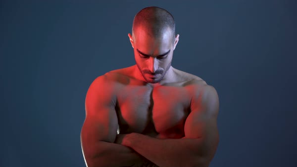 Male Fitness Model Flexing muscles, isolated on blue background. Studio ...