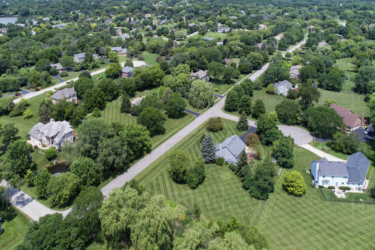 Aerial view of a luxury neighborhood with mature trees and large lots ...