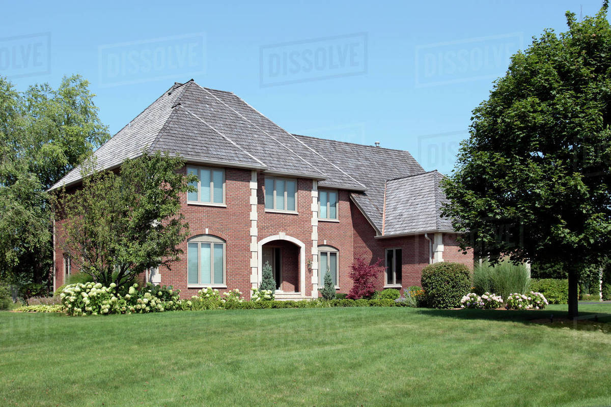 Large brick home with arched entry - Royalty-free Stock Photo | Dissolve