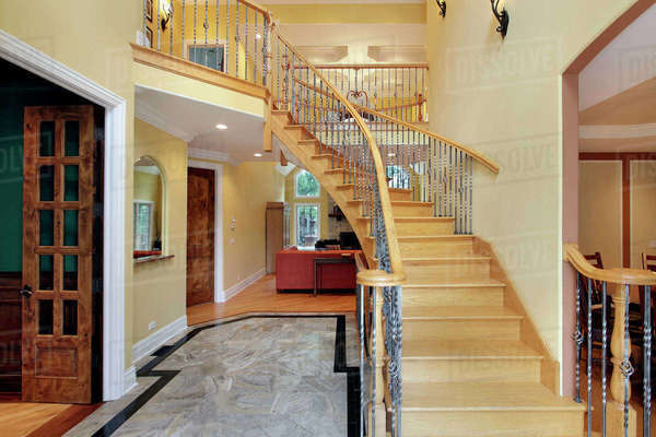 Foyer in suburban home with curved staircase. - Stock Photo - Dissolve