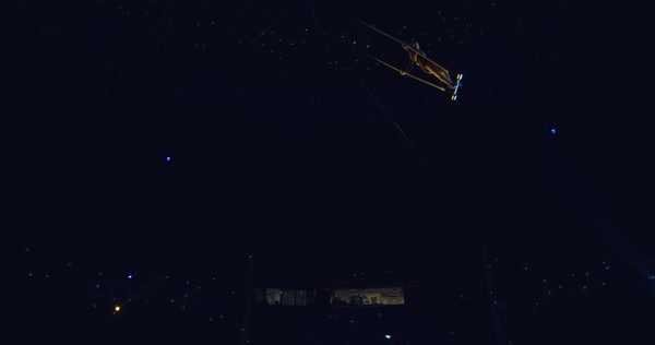 Circus show, young female performer is swinging from the ceiling ...