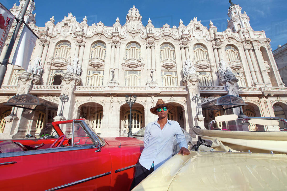 Taxi driver next to his vintage car in front of the Gran Teatro de La ...