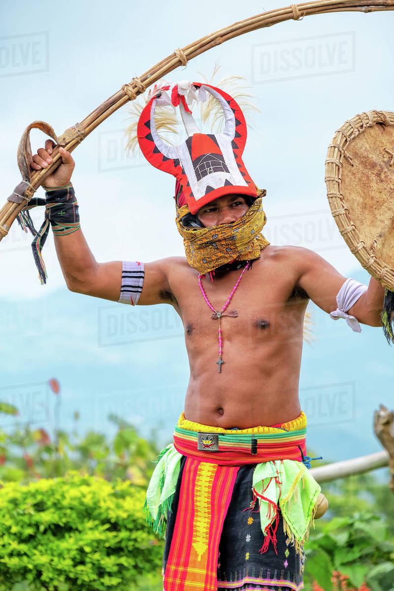 Caci man performing a traditional whip dance with bamboo shield and ...