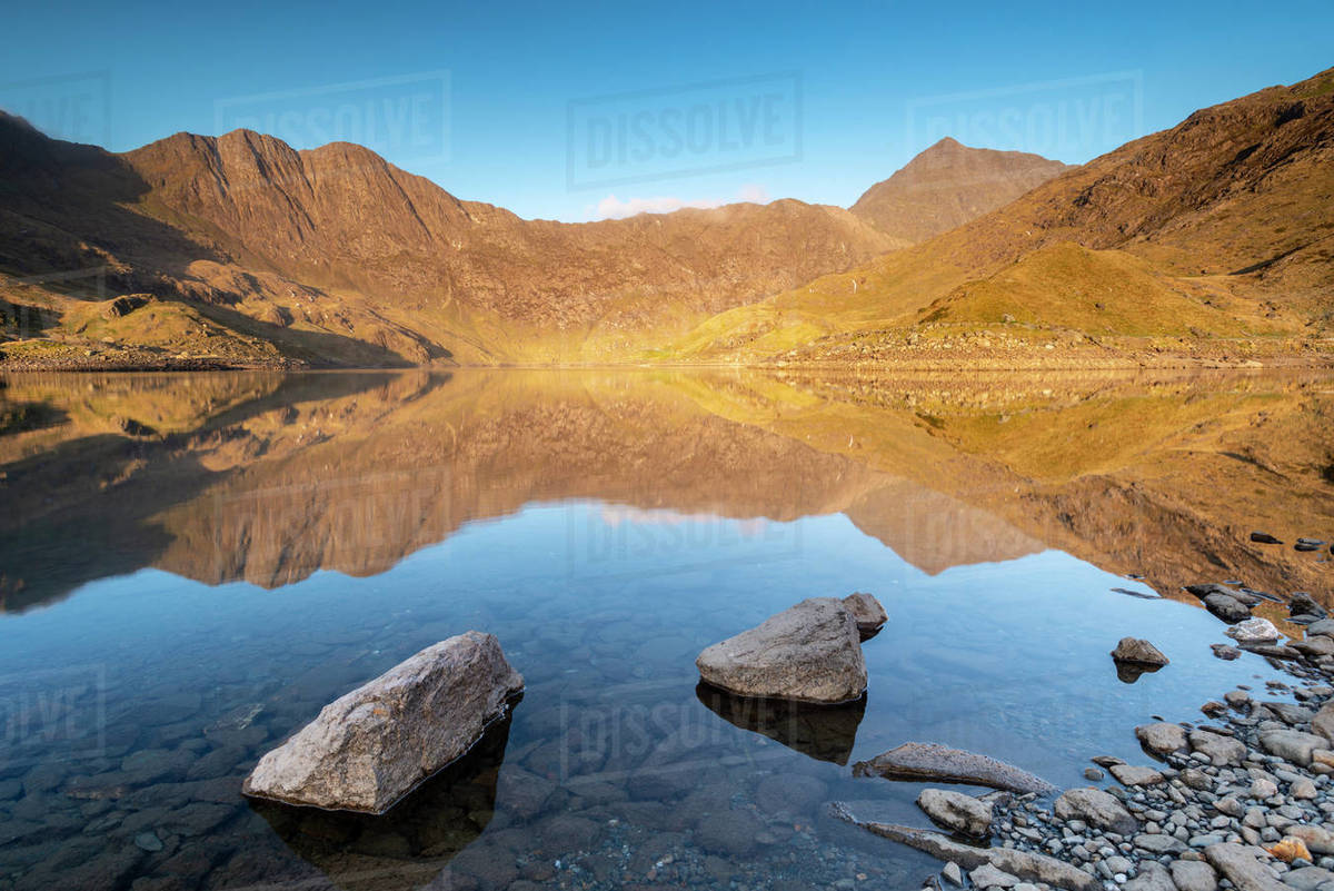 Early morning sunlight on Snowdon in spring, reflected in Llyn Llydaw ...