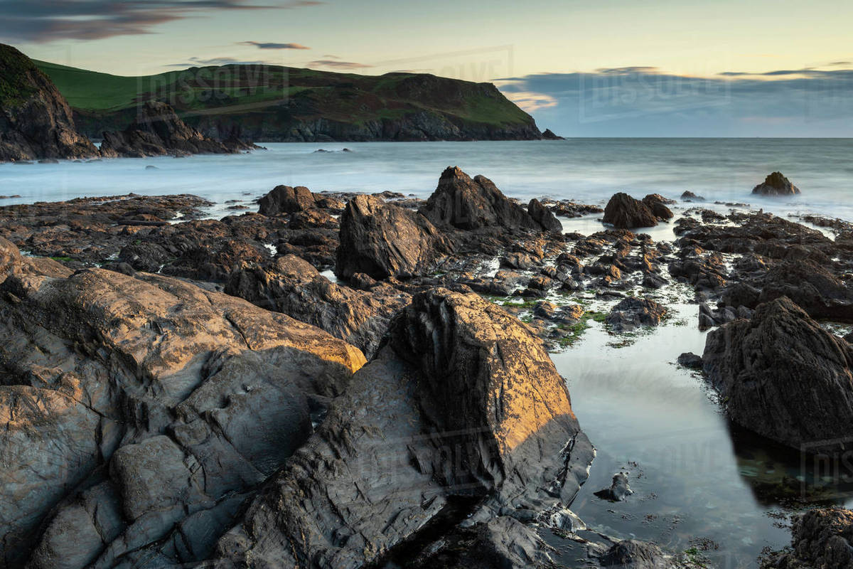 Evening sunlight on the rocky shores of Hope Cove, Devon, England ...