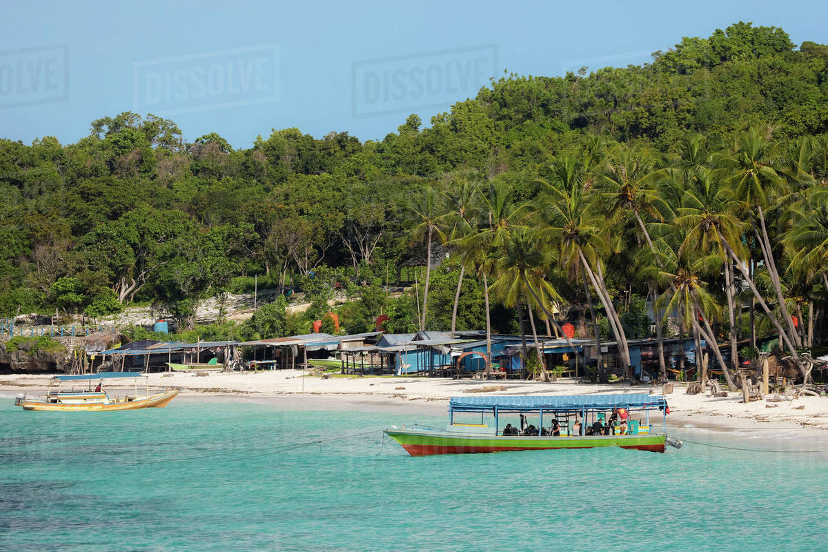 Tourist dive boat moored by white sand Bira Beach at far South resort ...