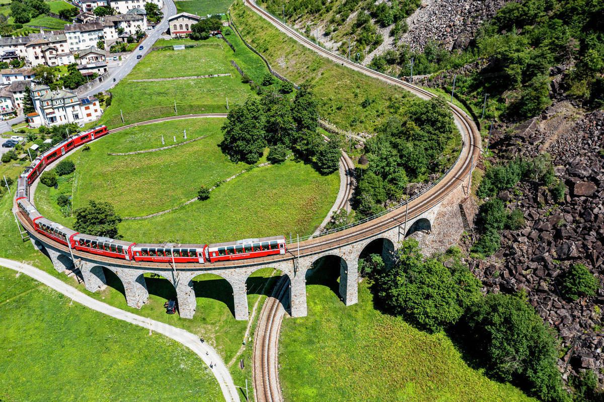 Aerial of a Train crossing the Brusio spiral viaduct, UNESCO World ...