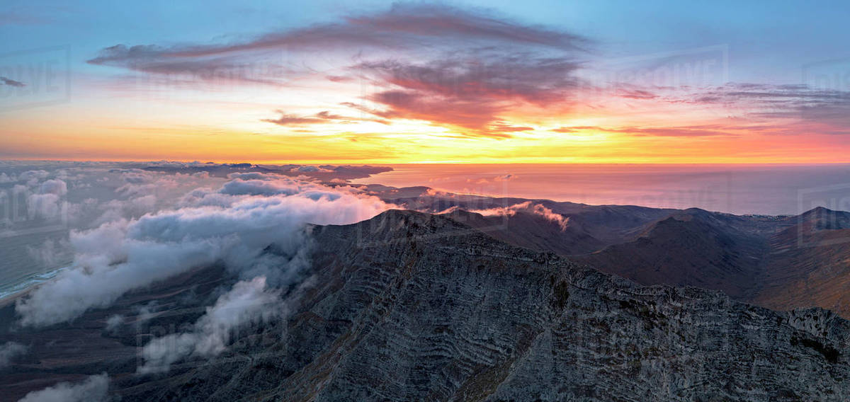 Burning sky at dawn over Pico de la Zarza mountain peak in a sea of ...