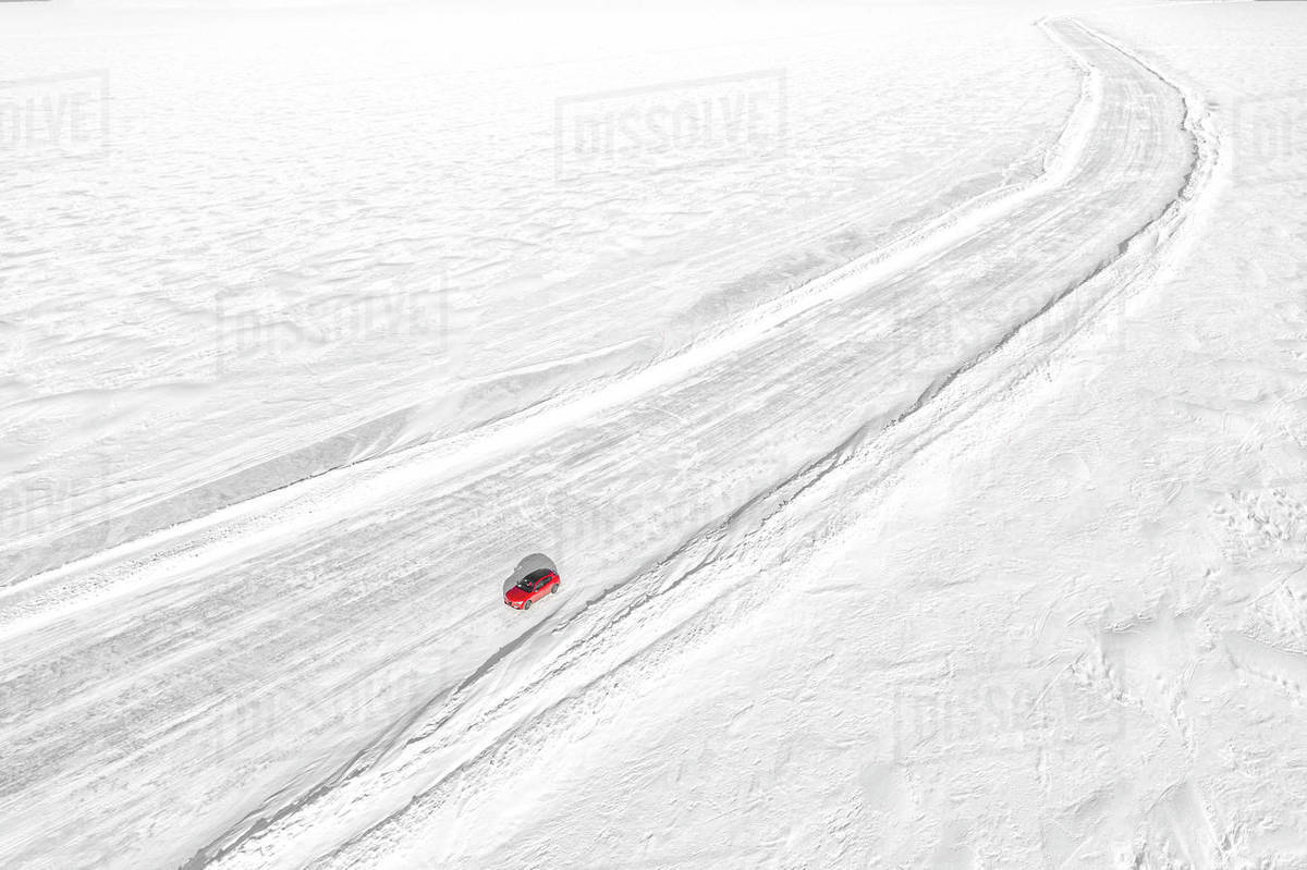 Aerial view of car traveling on empty ice road on the frozen sea, Lulea ...