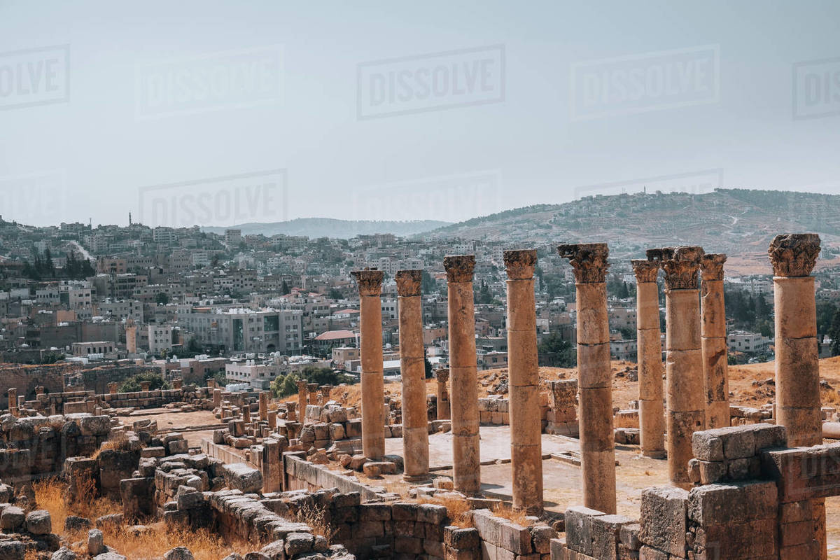The ruins of a Roman temple, with the modern city of Jerash in the ...