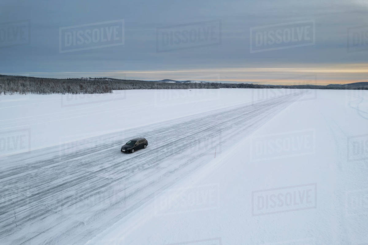 Car on icy road on a frozen lake from above, aerial view, Lapland ...