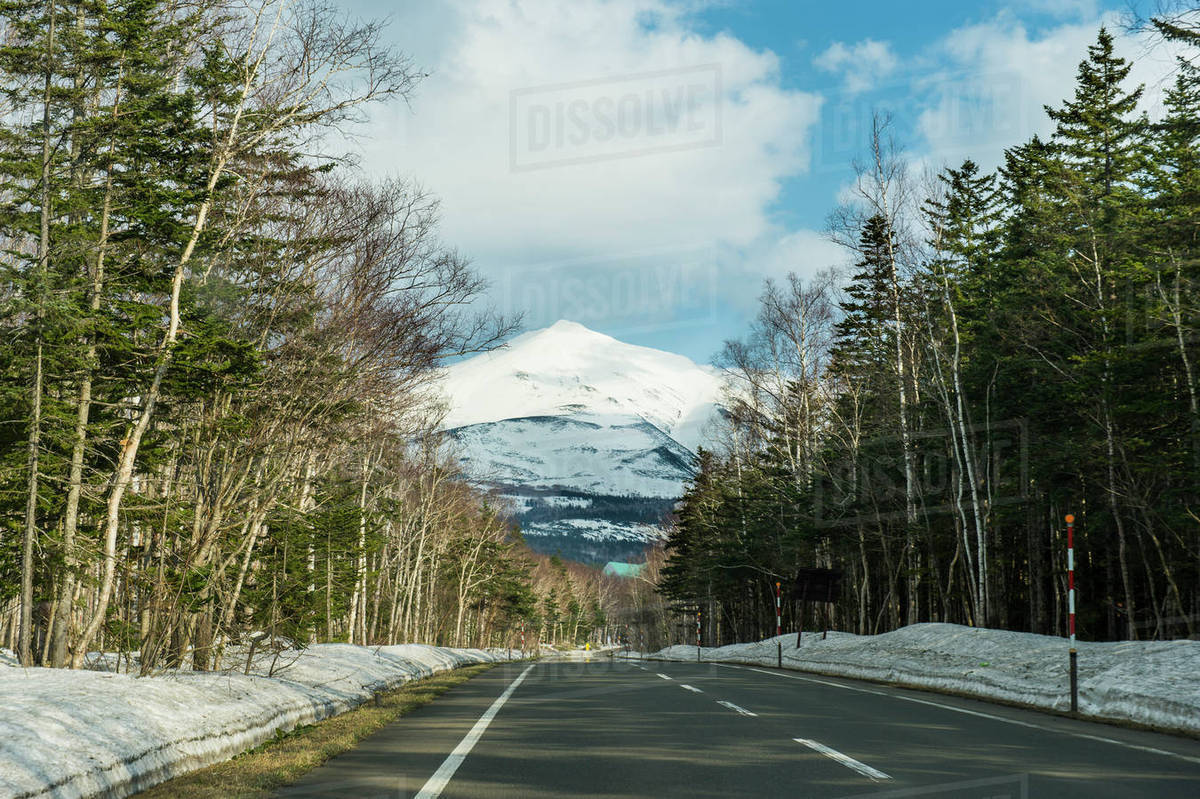 Road leading through the snow capped mountains of the Daisetsuzan ...