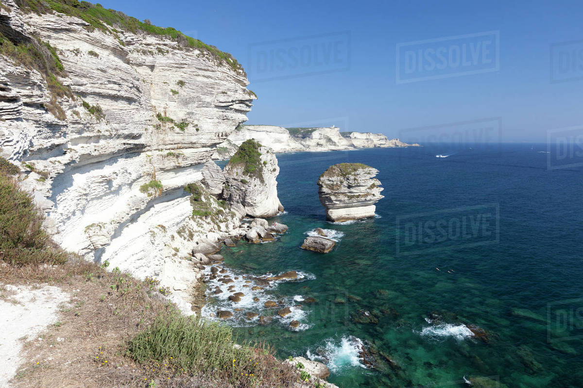 Sun shines on the white limestone cliffs framed by the turquoise sea ...