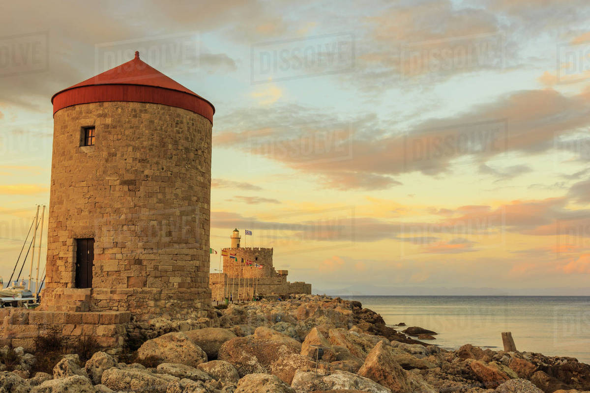 Mandraki Harbour medieval windmill and Fortress at sunset, Rhodes Town ...