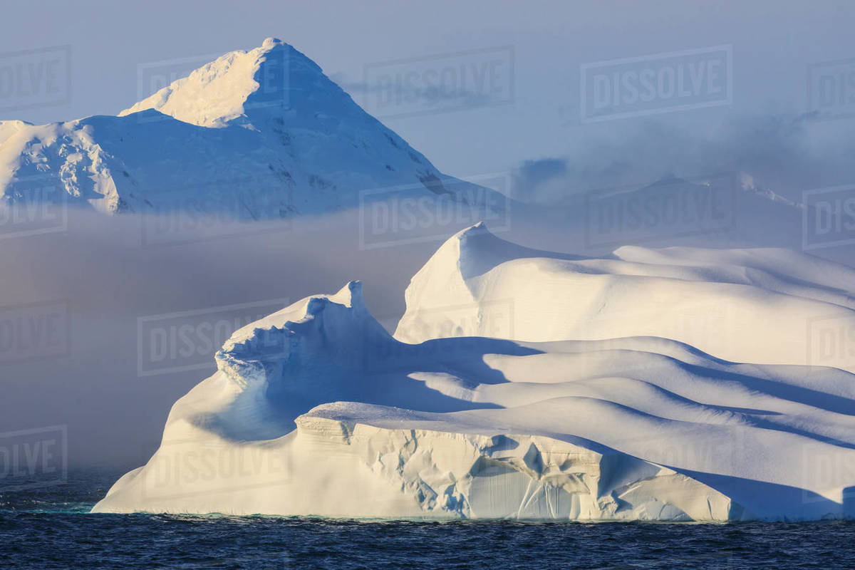 Huge non-tabular iceberg, mountains, evening light and mist, Bransfield ...