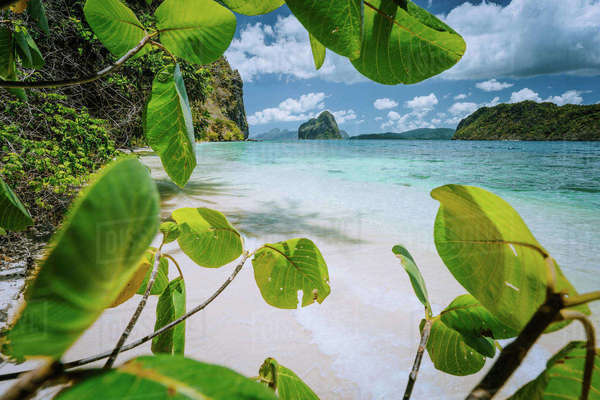 Tropical beach scenery with rocky islands and impressive clouds, framed ...