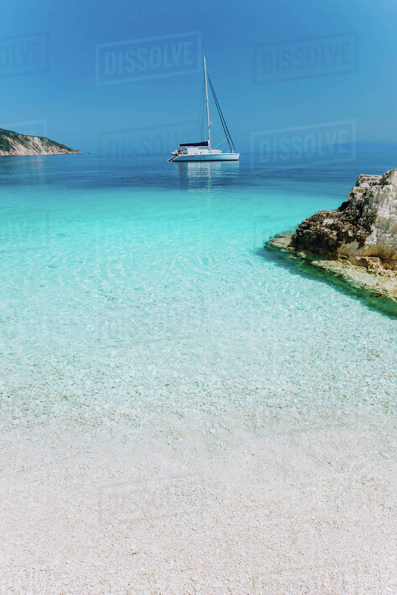 Beautiful azure blue lagoon with sailing catamaran yacht boat at anchor ...
