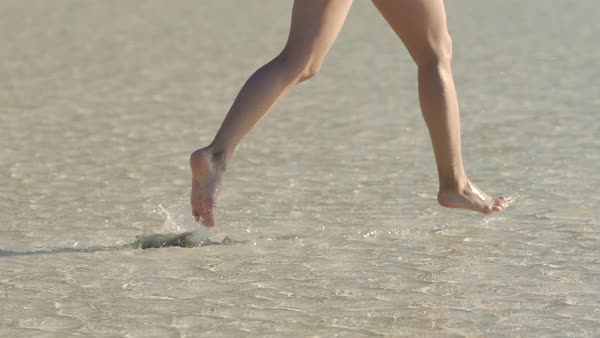 nice legs of a pretty girl running in water. Sport, lifestyle, health ...