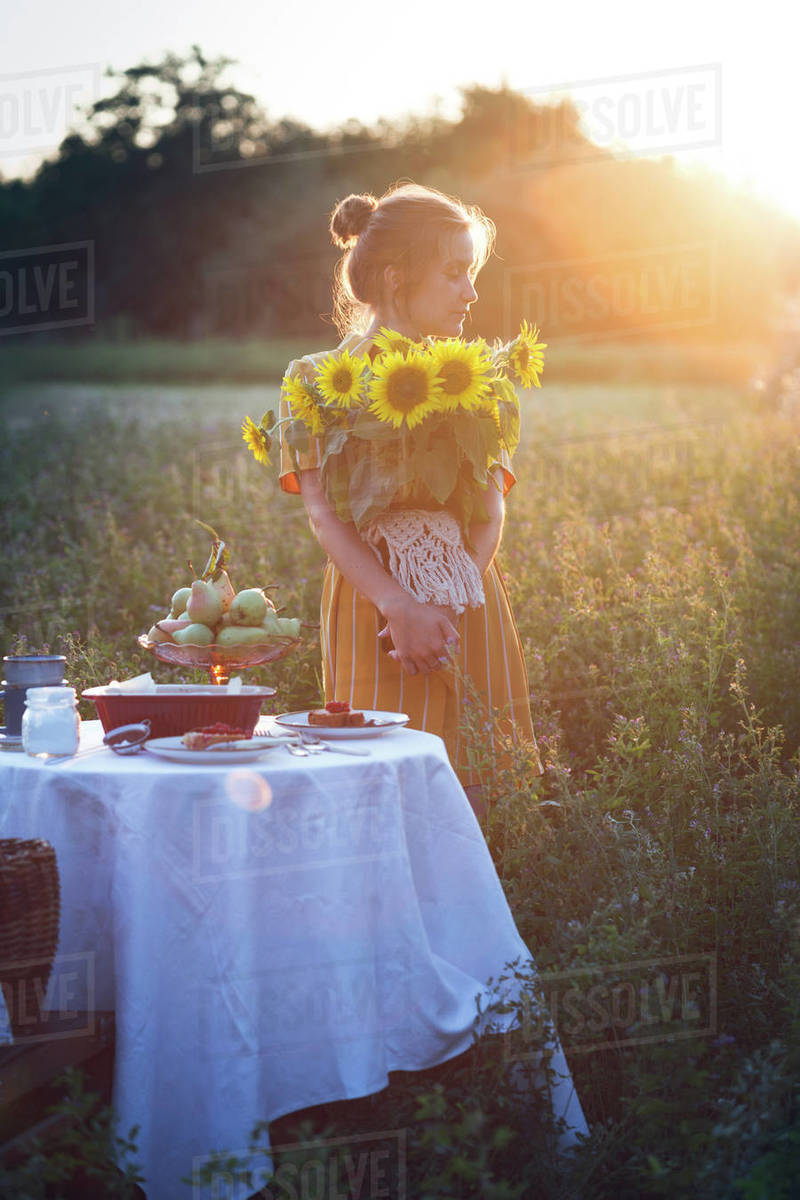 Garden and still life. tea party in the garden - girl and bouquet with sunflowers on the table ...