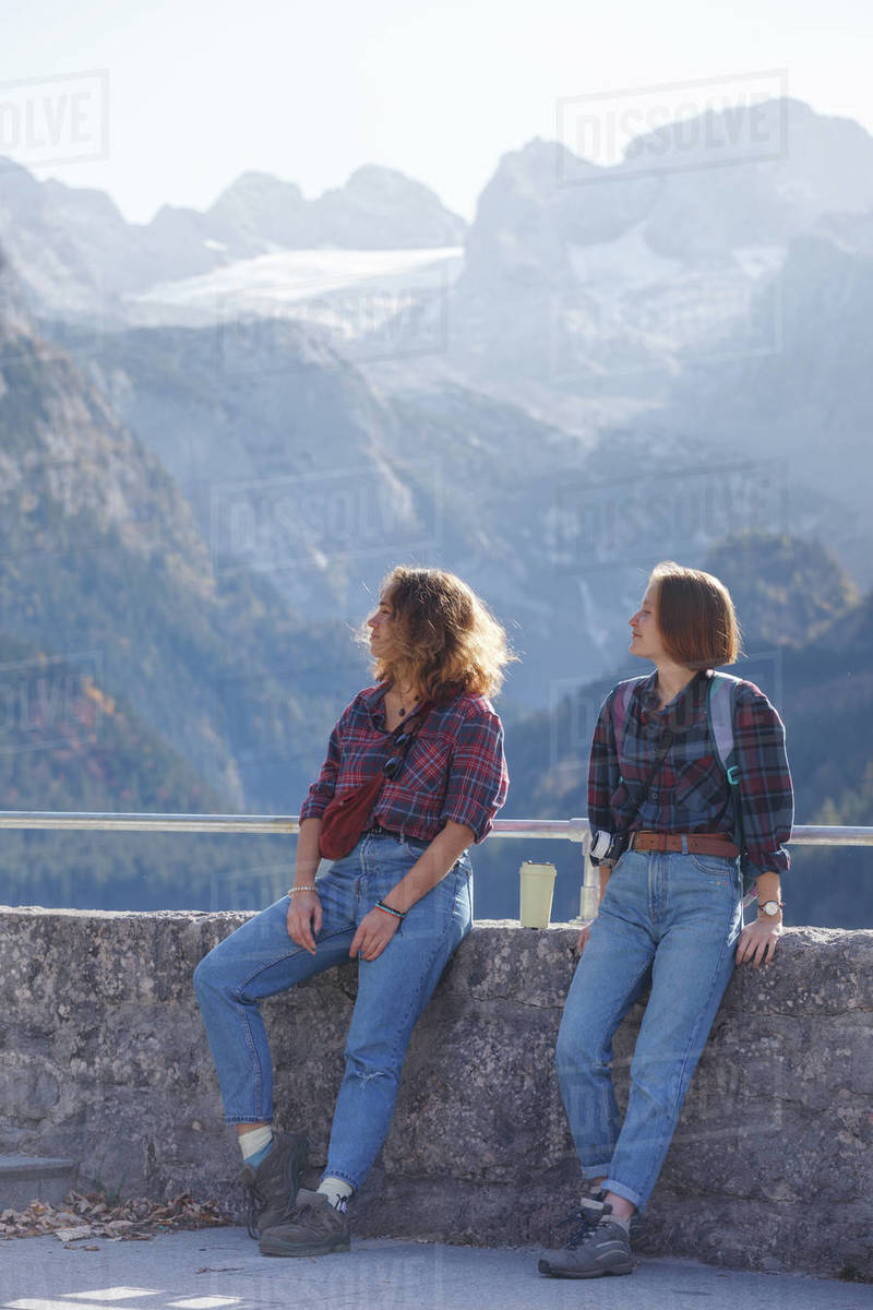 Mountain trip. two happy girls on the background of a mountain lake and ...