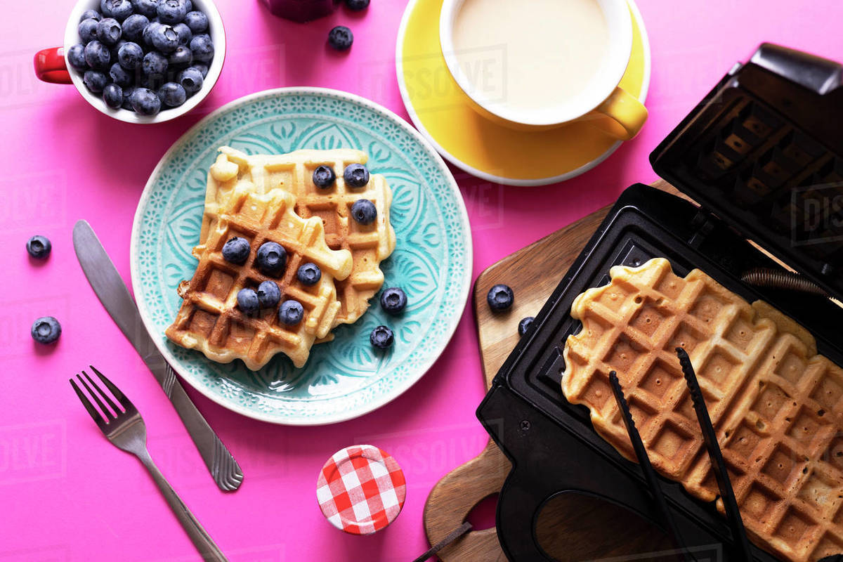 Morning and bright breakfast on the pink background. belgian waffles ...