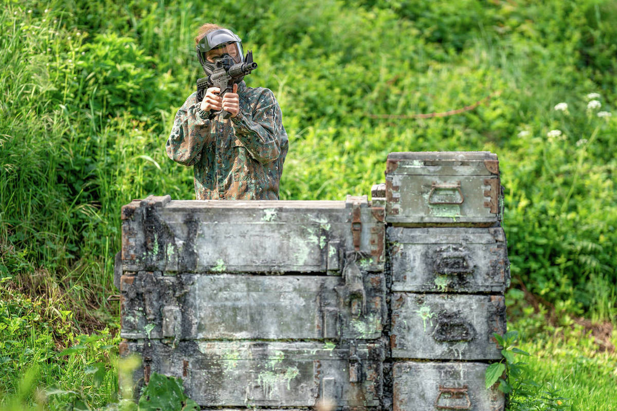 woman in uniform with a gun in military paintball training. - Royalty ...
